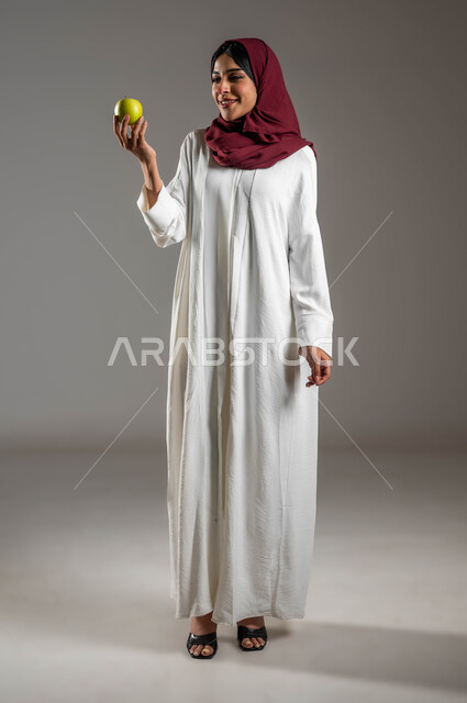 Following a healthy diet and eating fresh fruit, portrait of a Saudi ...