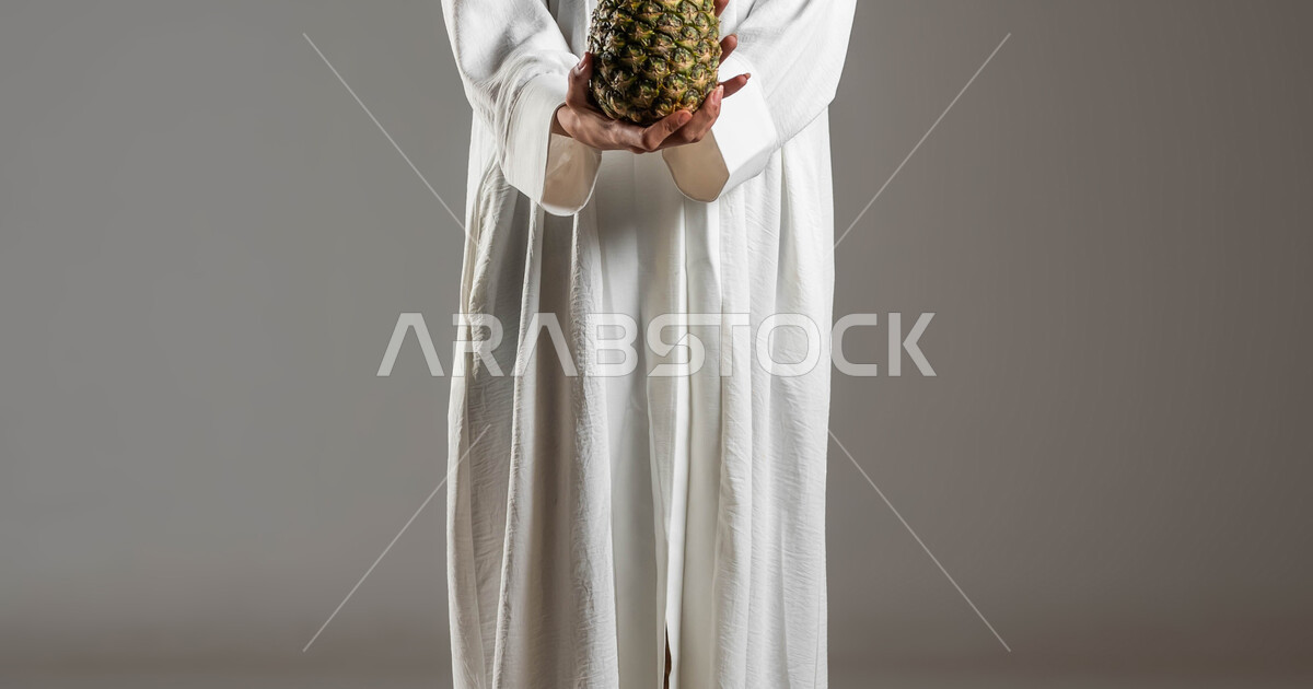 Fresh summer fruit, portrait of a Saudi Arabian Gulf woman wearing a ...