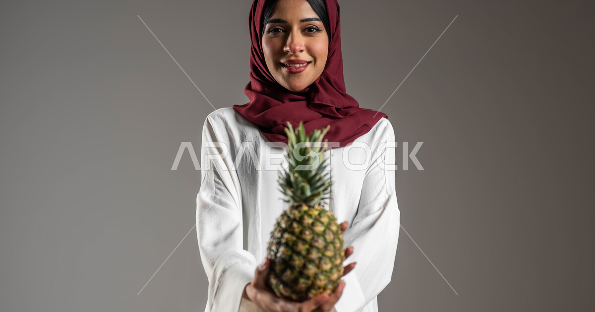 Natural and fresh summer fruits, a close-up portrait of a smiling Saudi ...