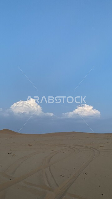 A close-up of sand dunes, golden sand in the Saudi desert, white clouds ...