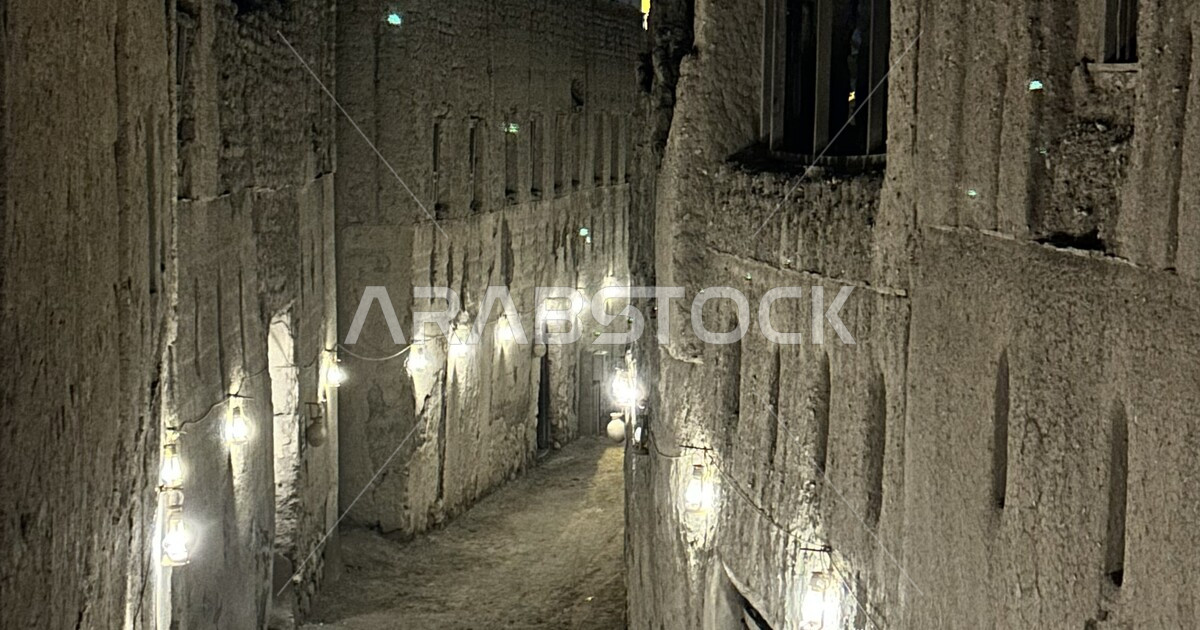 An Arab young man standing between old-style heritage stone buildings ...