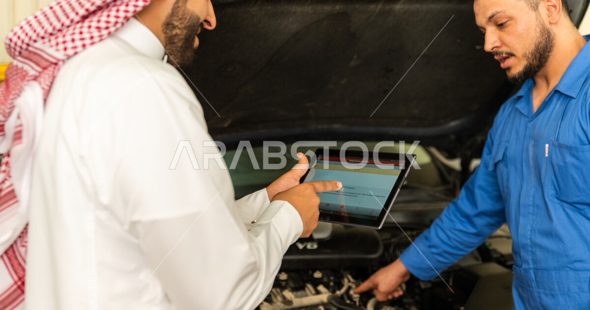 A Saudi Arab man inside the car repair shop, he pays cash to the ...