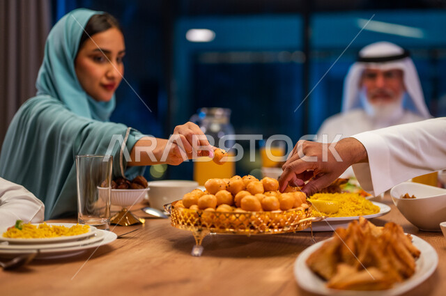 A dinner full of delicious food, a close-up of a Saudi Gulf Arab woman ...