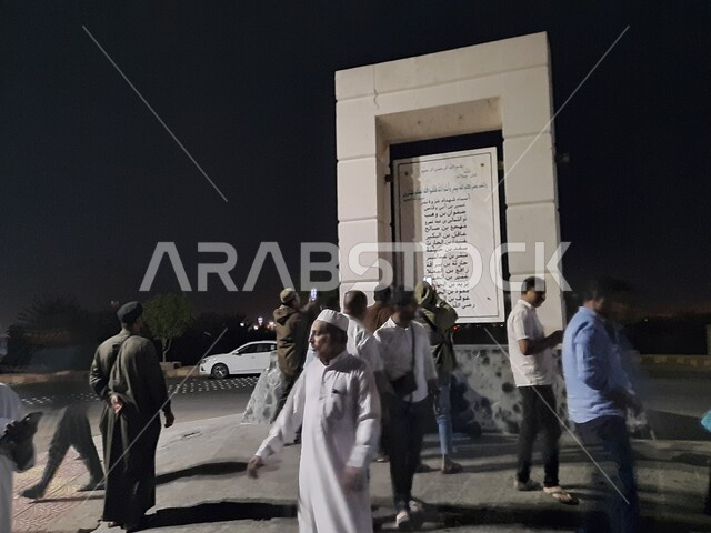Visitors gathered around the sign introducing the names of the martyrs ...