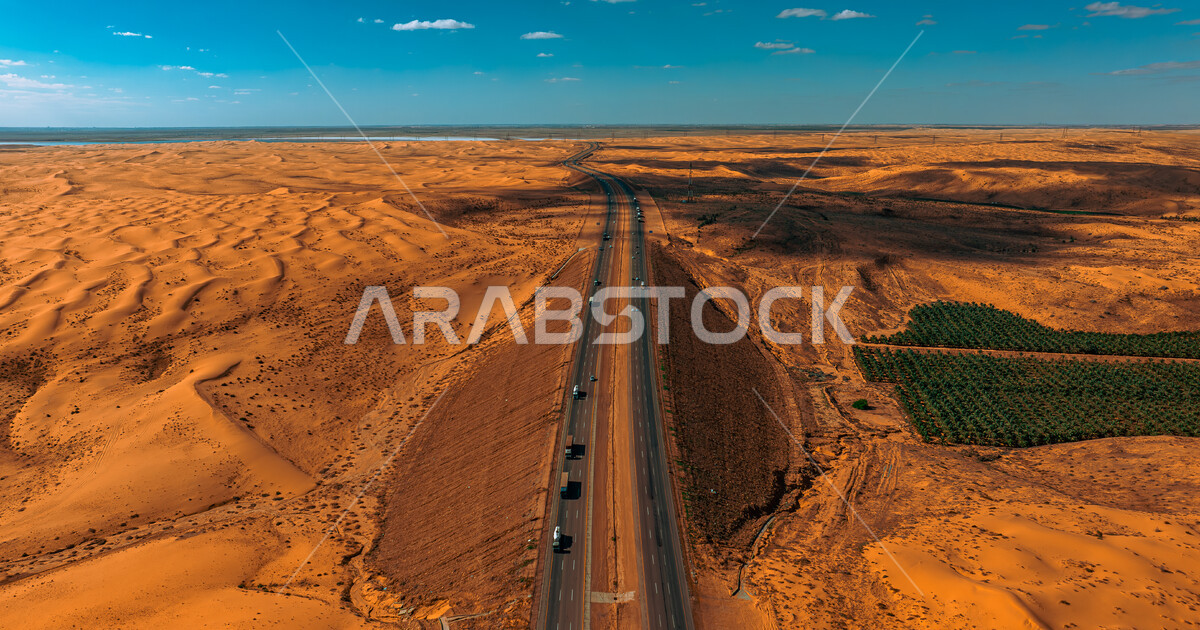 A paved asphalt travel road between the sand dunes in Al-Ghat ...
