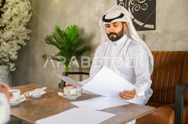 Saudi employees working on a project in a cafe , exploring business ...
