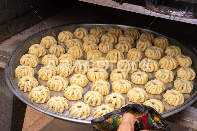 Placing discs of maamoul with ajwa and dates in trays, traditional ...