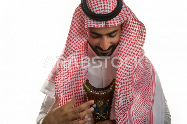 Portrait of a Saudi Arabian man carrying incense holder (incense burner ...