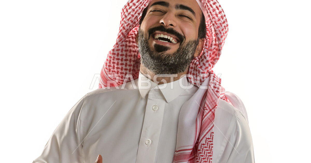 Portrait of a Saudi Gulf man laughing with facial gestures indicating ...