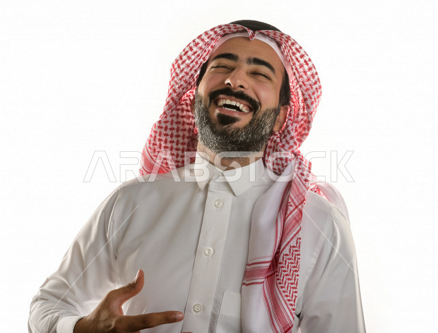 Portrait of a Saudi Gulf man laughing with facial gestures indicating ...