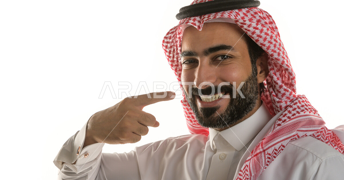 Portrait of a Saudi Gulf man laughing with facial gestures indicating ...