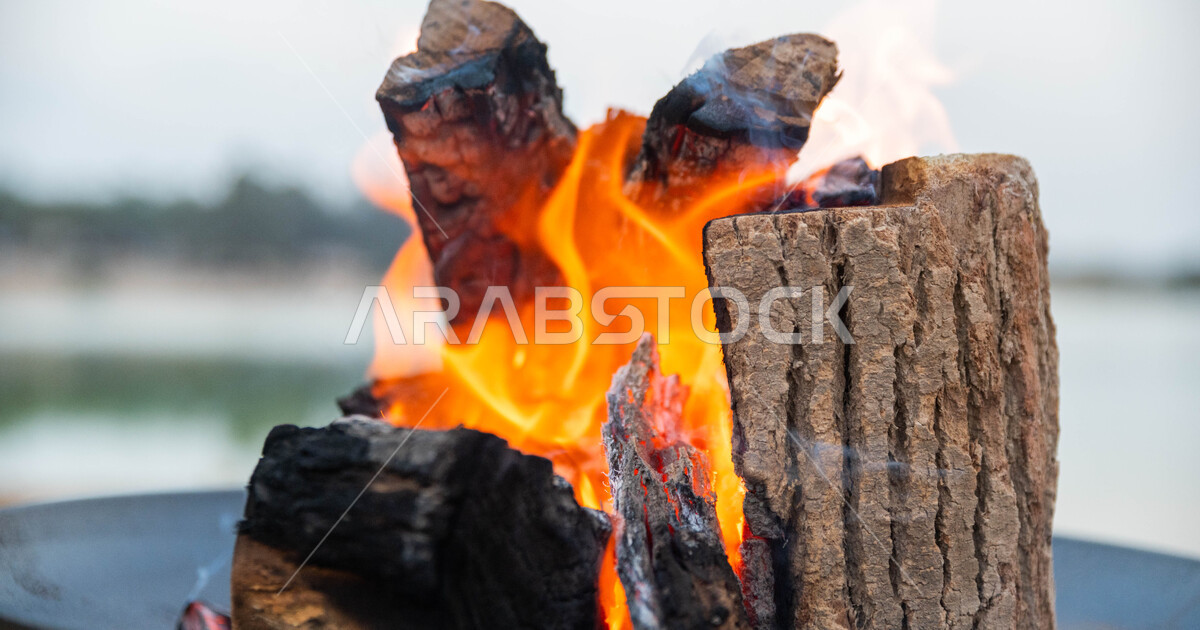 A bonfire is burning on one of the road trips in the desert of Saudi ...