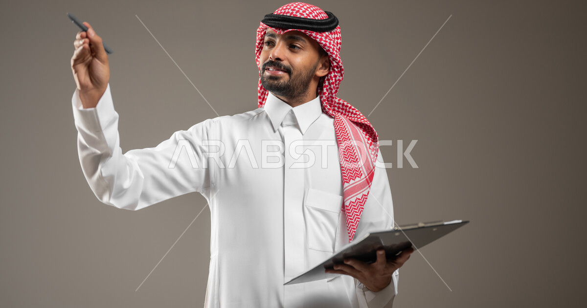 Taking and recording notes and ideas, a close-up portrait of a Saudi ...