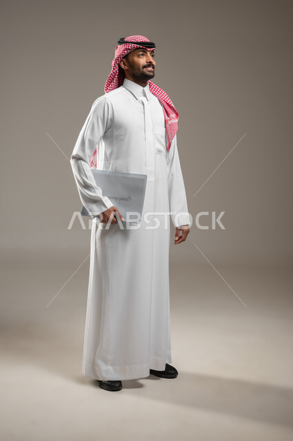 A full-length side portrait of a Saudi Gulf Arab man wearing Saudi ...