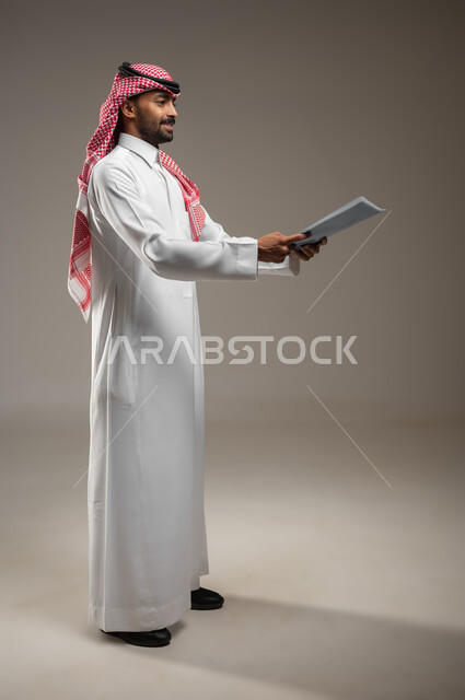 A full-length side portrait of a Saudi Gulf Arab man wearing the Saudi ...