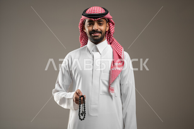 A close-up portrait of a Saudi Gulf Arab young man wearing the Saudi ...