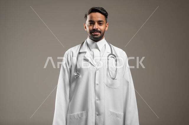 A close-up portrait of a Saudi-Gulf Arab doctor wearing a white medical ...