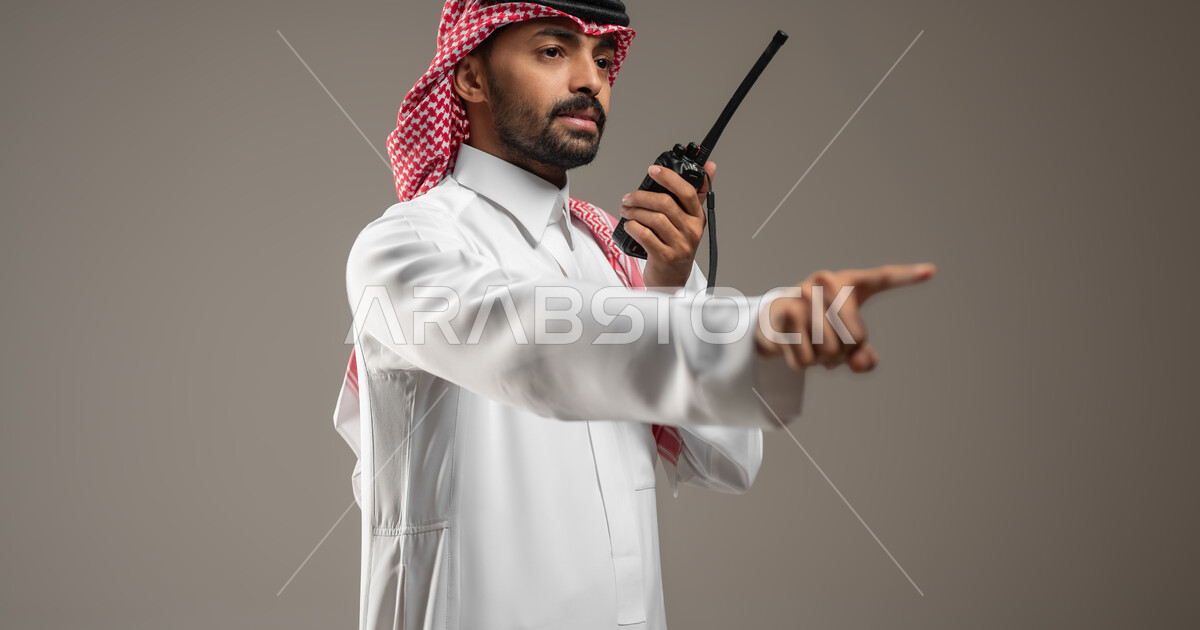 A close-up portrait of a Saudi Gulf Arab man wearing Saudi uniform ...