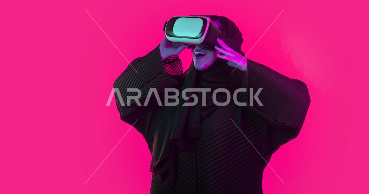 Portrait of a happy Saudi Arabian Gulf woman, wearing a VR Box, face ...