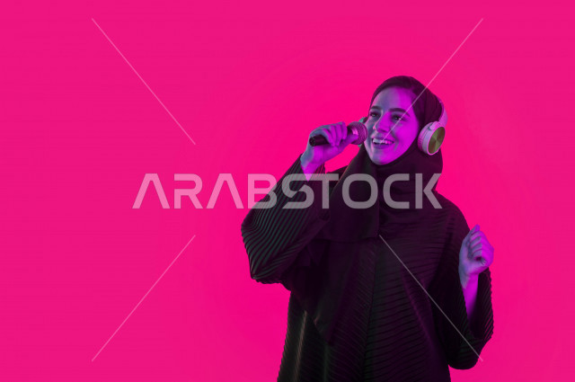 Portrait of a happy Saudi Arabian Gulf woman, carrying the microphone ...