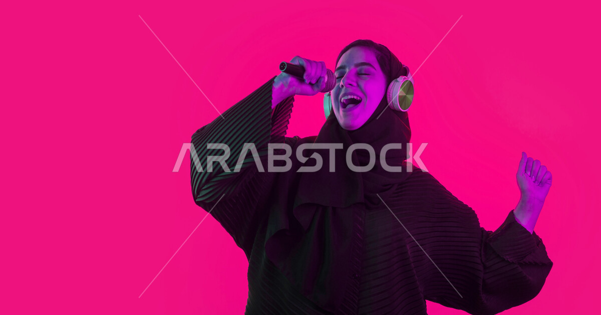 Portrait of a happy Saudi Arabian Gulf woman, carrying the microphone ...
