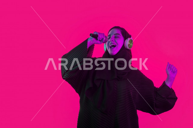 Portrait of a happy Saudi Arabian Gulf woman, carrying the microphone ...