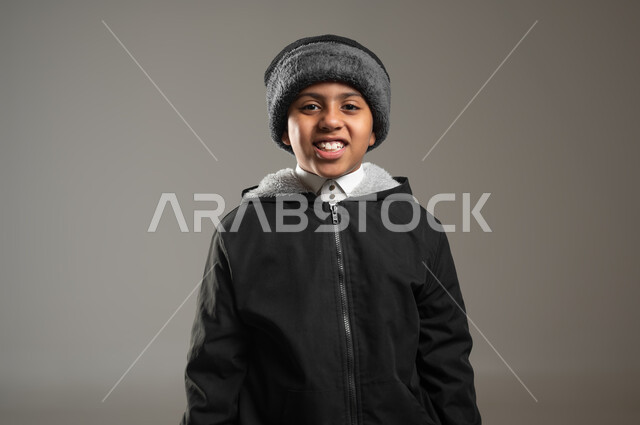 البرد القارس لفصل الشتاء، بورتريه مقرب لولد عربي خليجي يرتدي الثوب ...