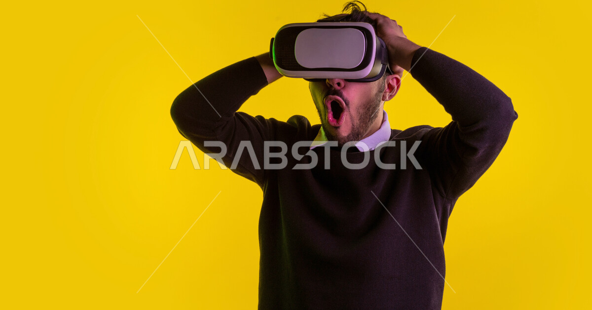 Portrait of a happy Saudi Gulf man, putting up a VR Box, face and hands ...
