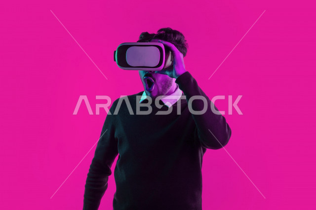 Portrait of a happy Saudi Gulf man, putting up a VR Box, face and hands ...