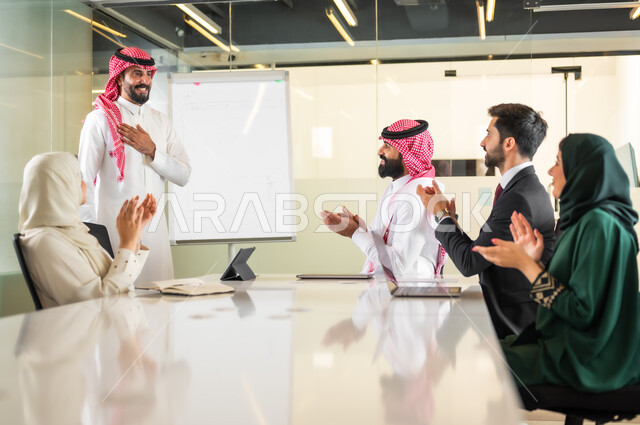 A Saudi Gulf Arab team in a meeting inside the office, gestures of ...