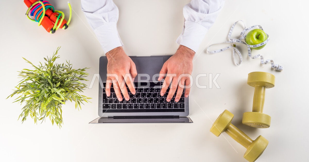 Close up from the top, of a sports coach working on a laptop on a white ...