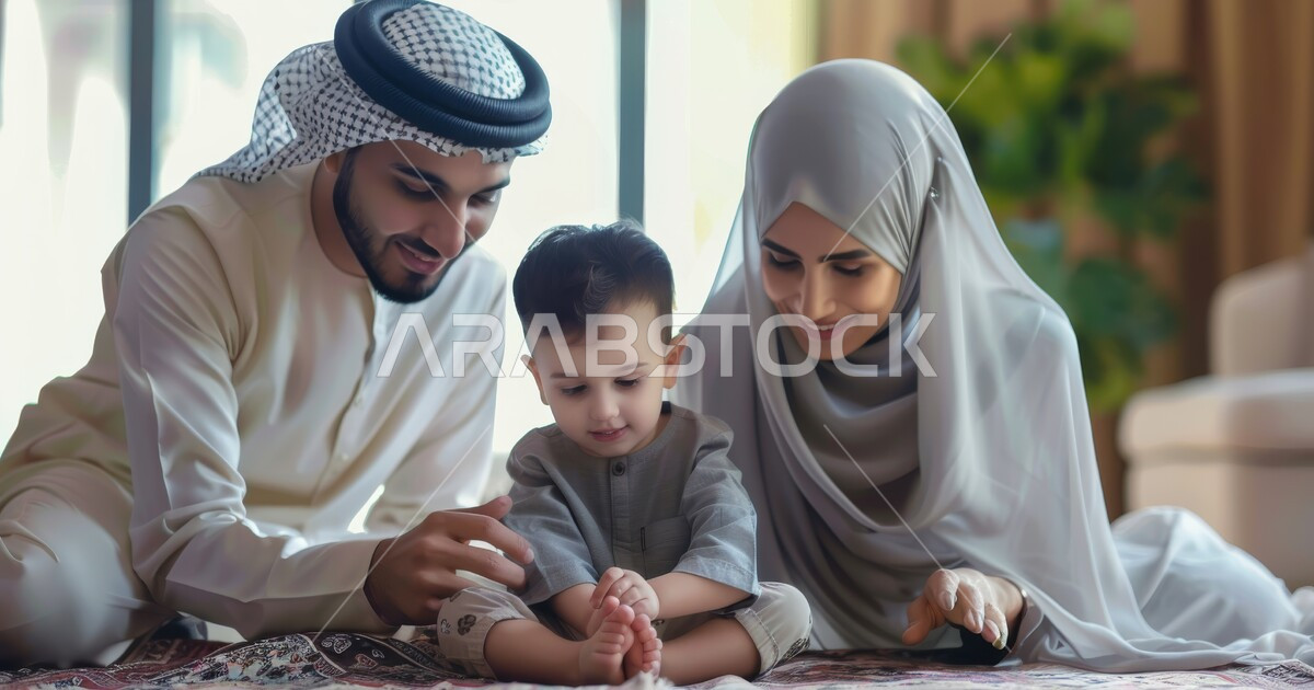 A Saudi Gulf Arab family sitting in the living room practicing ...