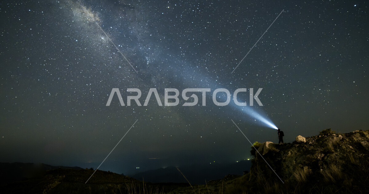 A man standing on the mountain peaks and heights in the Taif region in ...