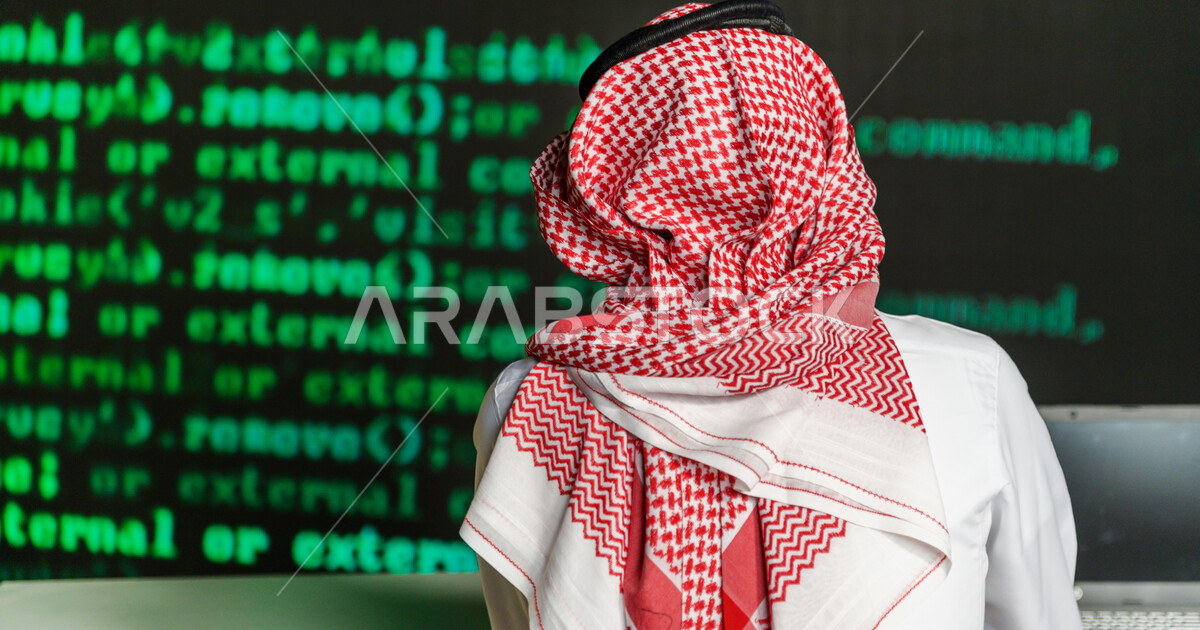 A young Saudi Gulf Arab working as a web developer, using a variety of ...