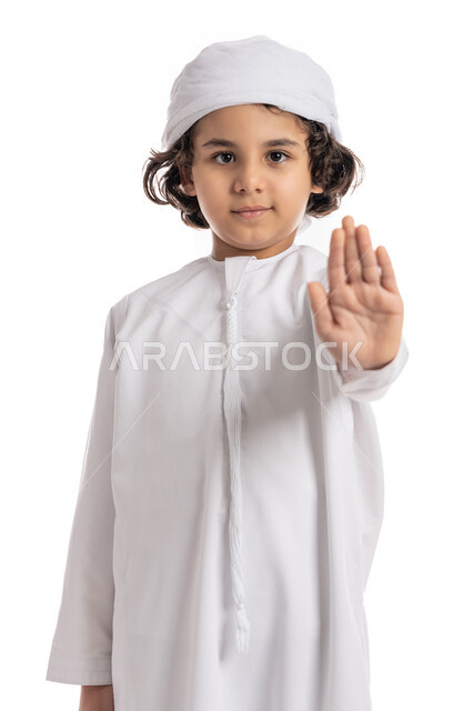 A Saudi boy standing with hand gestures indicating the command to stop ...