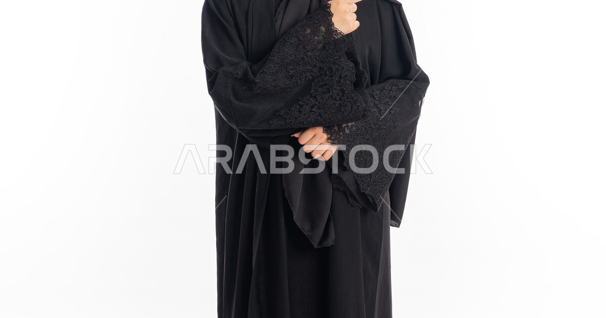 الوقوف باستقامة والاشارة إلى شيء ما، سيدة سعودية تنظر إلى الكاميرا بإيماءات السرور, تعابير ...