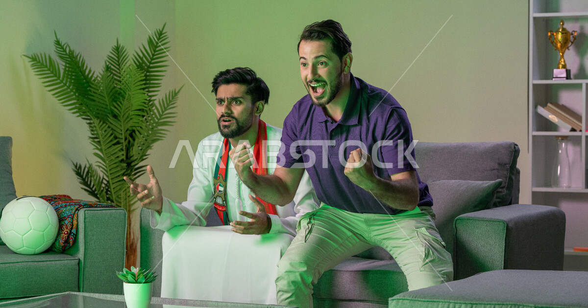 مشاهدة المباراة والحماس مع الاصدقاء , شابان عربيان اماراتيان خليجيان يشاهدان مباراة للدوري ...