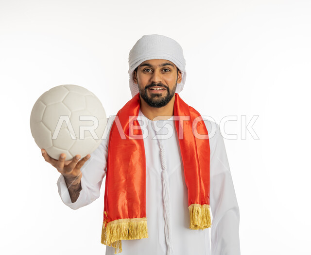 A supporter of Emirati sports teams and clubs, raising the ball with ...