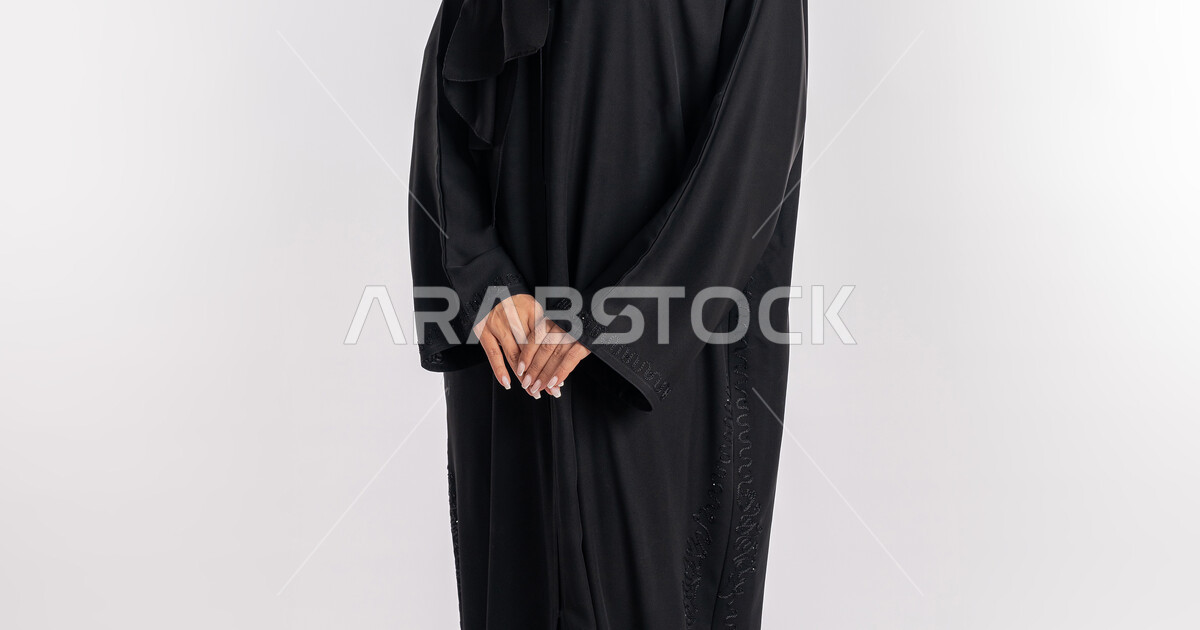 شابة سعودية تقف بأيدي متشابكة، أزياء محجبات عصرية راقية، مفهوم الأناقة والاهتمام بالمظهر الخارجي ...