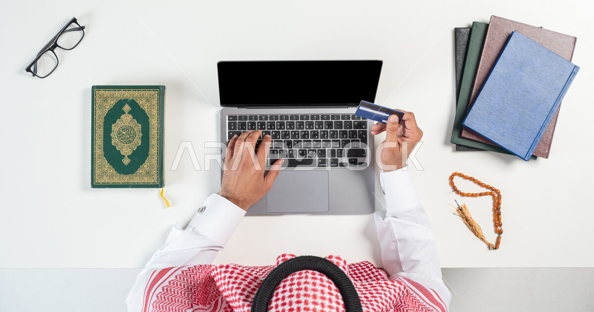 دمج التكنولوجيا بالحياة اليومية، بورتريه ليدي رجل عربي خليجي سعودي يقوم باستخدام الحاسوب المحمول ...