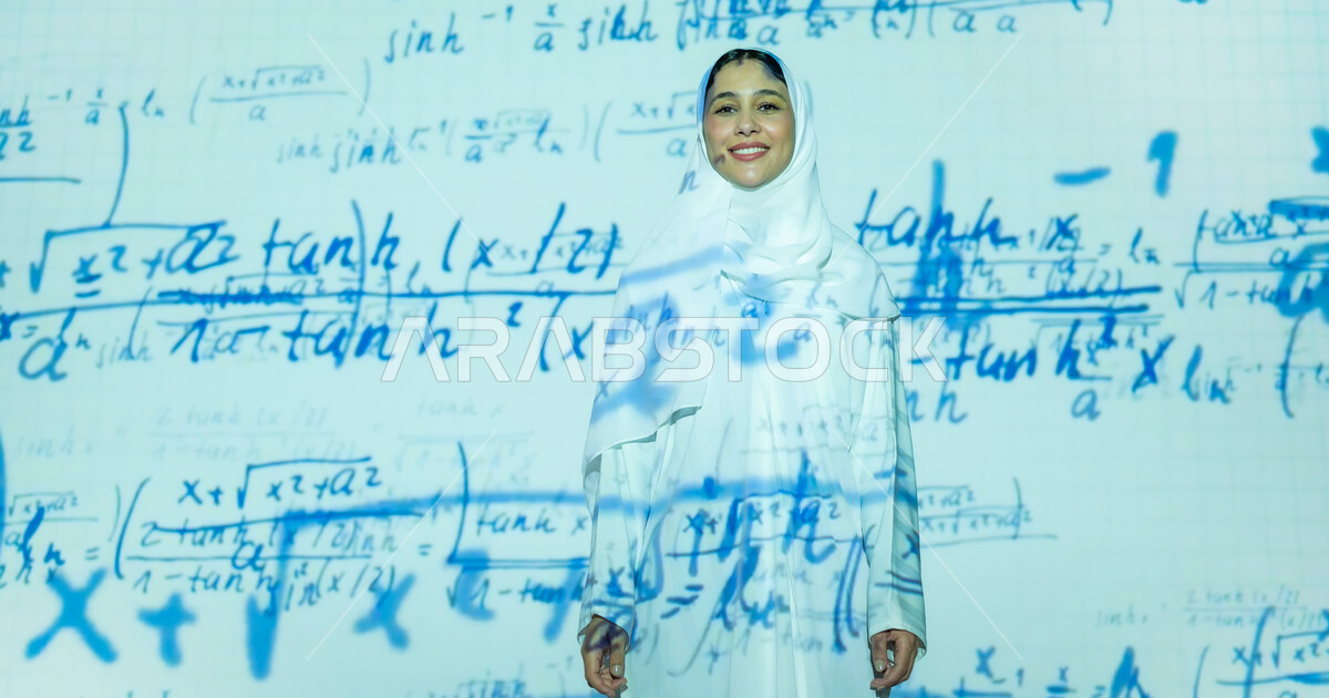أرقام وحسابات في مادة الرياضيات، امرأة عربية خليجية سعودية مبتسمة محجبة ترتدي العباءة تنظر الى ...