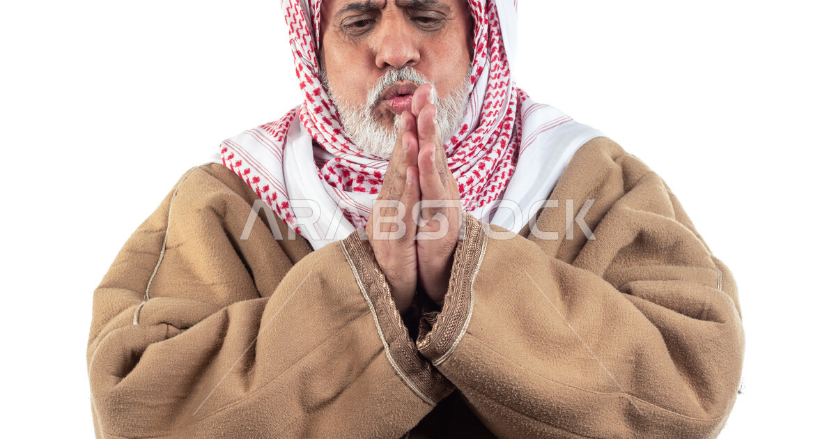 Portrait of an old Saudi Arab man feeling cold, wearing a Saudi bisht ...