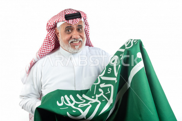Portrait of an old Saudi Arab man holding the flag of Saudi Arabia and ...