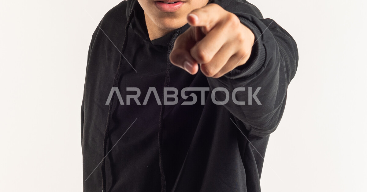 Portrait of a young Saudi Arabian Gulf teenager pointing his finger in ...