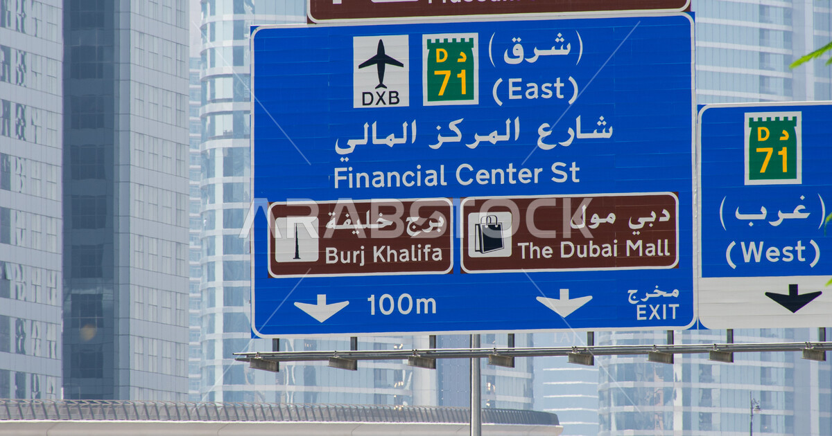 A large blue directional signboard in Arabic and English on Sheikh ...