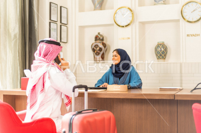 A veiled Saudi Gulf receptionist welcomes the Saudi guest at the ...