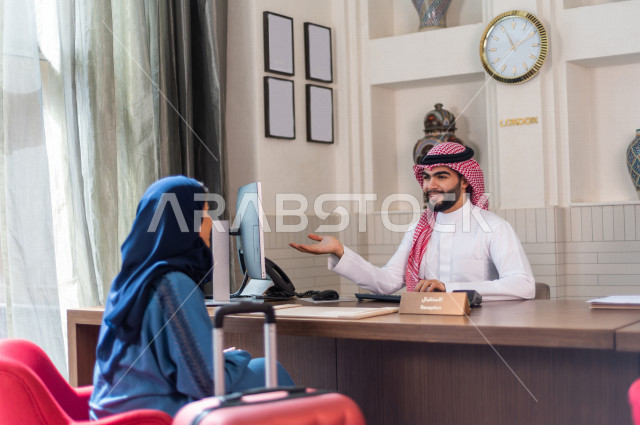 A Saudi Gulf receptionist welcomes the veiled Saudi female guest at the ...