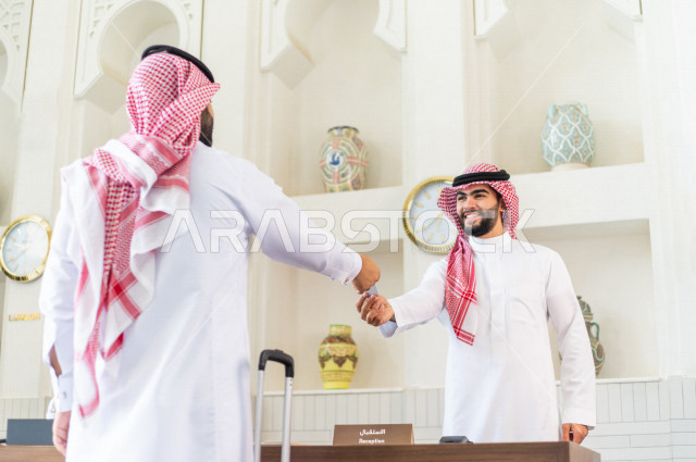 A smiling Saudi Gulf receptionist gives the key card to a Saudi guest ...