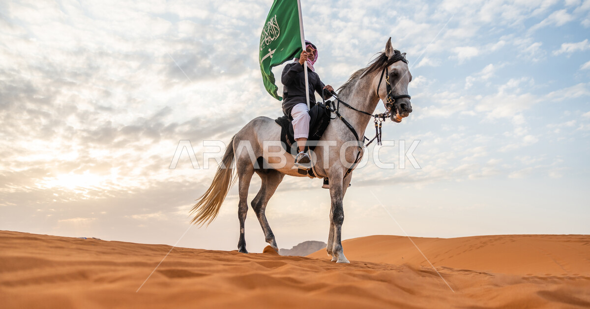 A Saudi Gulf rider riding a horse in the picturesque desert of Saudi ...