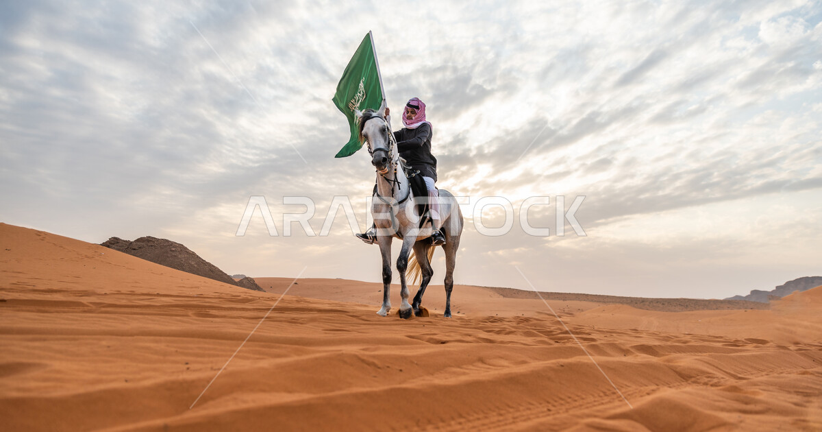 A Saudi Gulf rider riding a horse in the picturesque desert of Saudi ...